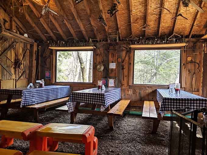 Checkered tablecloths on wooden benches with a dirt floor, because sometimes authenticity means skipping the concrete.