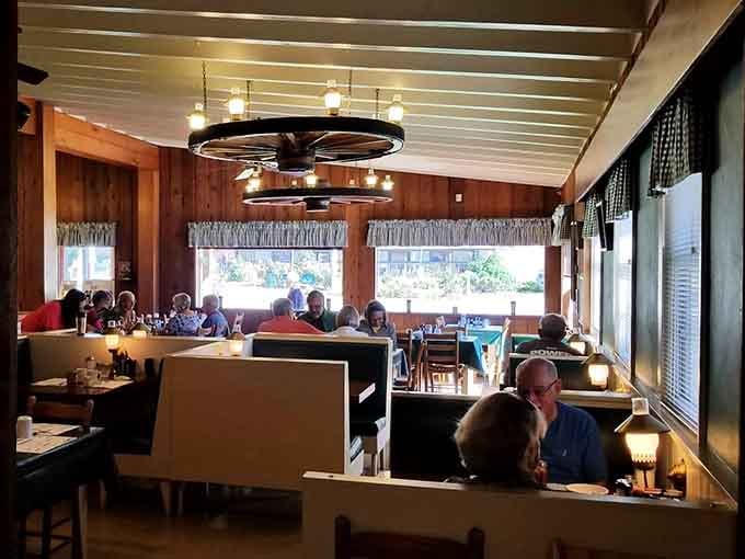 Wood paneling and wagon wheel chandeliers create the perfect cozy atmosphere for demolishing a stack of pancakes.