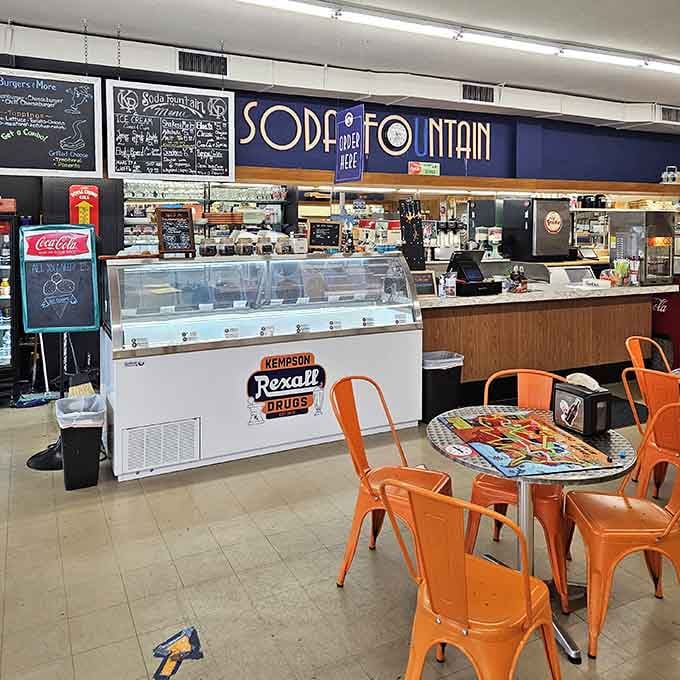 The blue "Soda Fountain" sign above the counter is basically a portal to 1955, minus the poodle skirts.