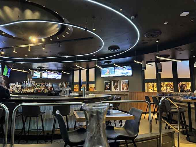 Modern sports bar meets upscale dining room, where circular lighting fixtures create ambiance that elevates the entire game-watching experience beautifully.