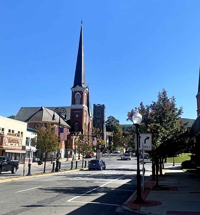 That church steeple pointing skyward like it's trying to get heaven's attention over the Berkshire peaks behind it.