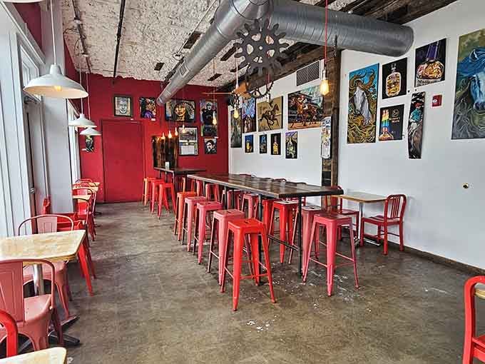 Industrial chic meets Italian comfort in a space where red chairs and exposed ductwork create unexpected magic.