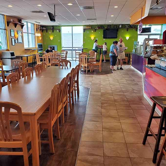 Bright walls and wooden tables create the kind of welcoming space where strangers become friends over pizza slices.