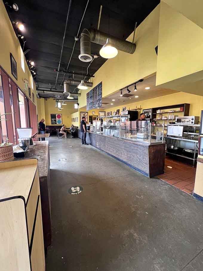 Industrial chic meets neighborhood warmth in a space where exposed ceilings feel surprisingly cozy and inviting.