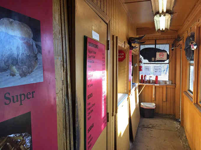 Wood-paneled walls and pink menu boards: where function meets no-nonsense charm in the best possible way.