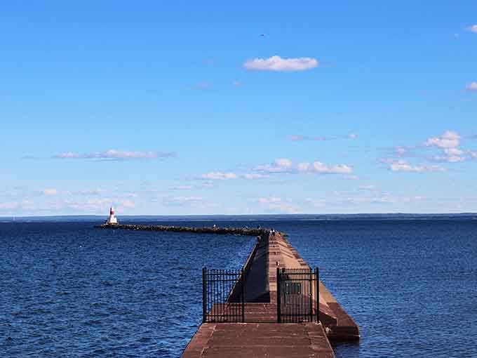 The lighthouse stands guard like a faithful friend, waiting patiently at the end of its breakwater runway.