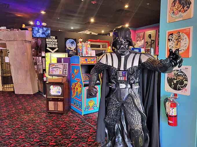 Darth Vader standing guard among vintage arcade cabinets feels oddly right, like he finally found his retirement gig.