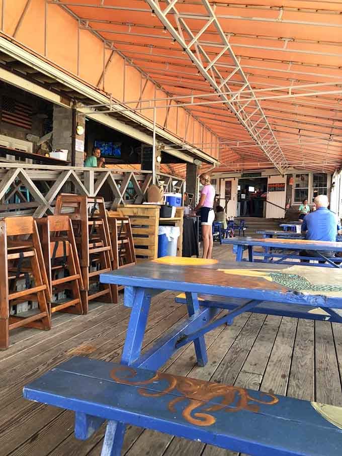 The covered deck offers shade, cold drinks, and the kind of relaxation you thought only existed in vacation commercials.