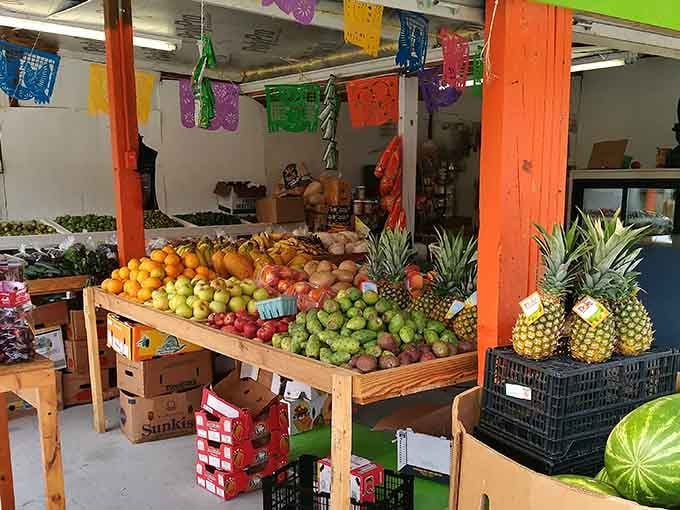 Fresh pineapples standing at attention next to vibrant apples &ndash; nature's candy store meets international marketplace vibes.