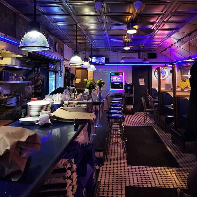Purple-lit chrome and classic counter stools create an atmosphere that's equal parts nostalgia and late-night urban energy.