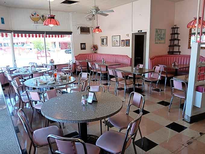 Pink vinyl booths and checkered floors create a time machine powered entirely by nostalgia and hot fudge sauce.