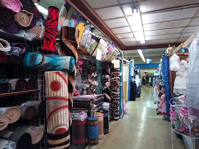 Rows of colorful rugs stacked high create a textile canyon where home decorators find their design dreams.