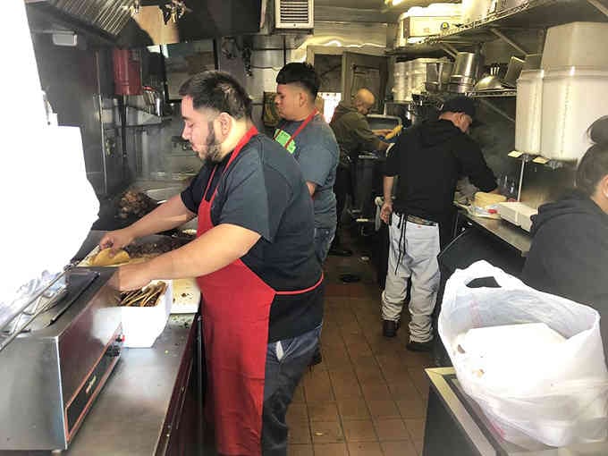 Behind the scenes, the kitchen hums with focused energy as skilled hands craft taco perfection.