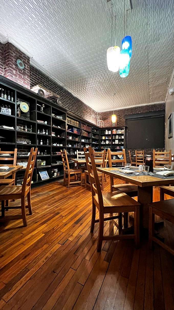 Exposed brick, warm wood floors, and tin ceilings create an atmosphere that feels like dining in someone's beautifully restored home.