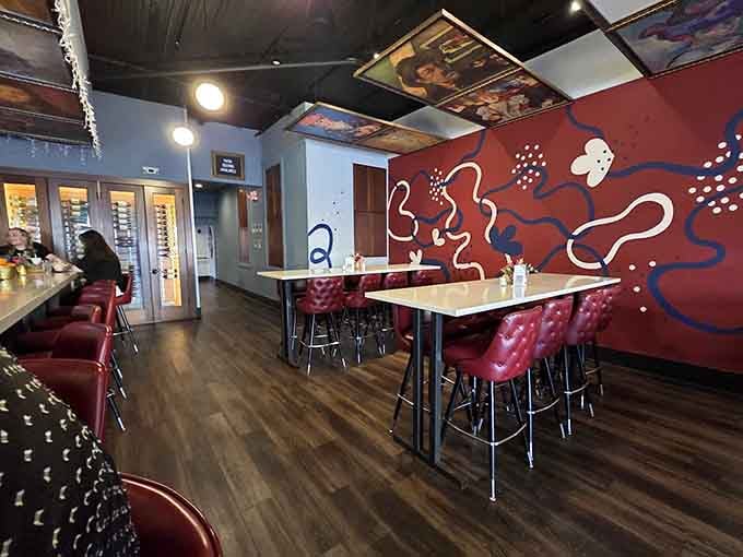 Bold red walls meet modern art in a space that proves dining rooms can be galleries too.