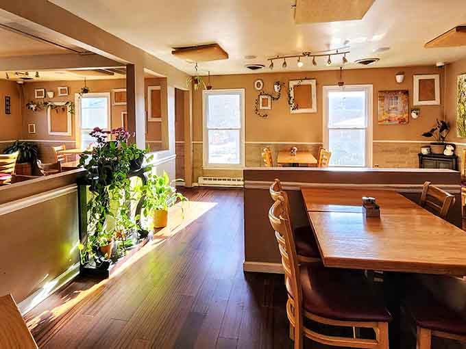 Sunlight streams through windows onto wooden tables in this cozy dining room that feels like home.