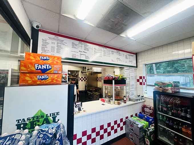 Classic checkered counter, gleaming pizza warmer, and that unmistakable aroma prove great food doesn't need fancy surroundings.
