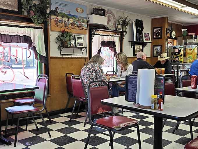 Classic checkered floors and burgundy chairs create the kind of timeless diner atmosphere Norman Rockwell would paint.
