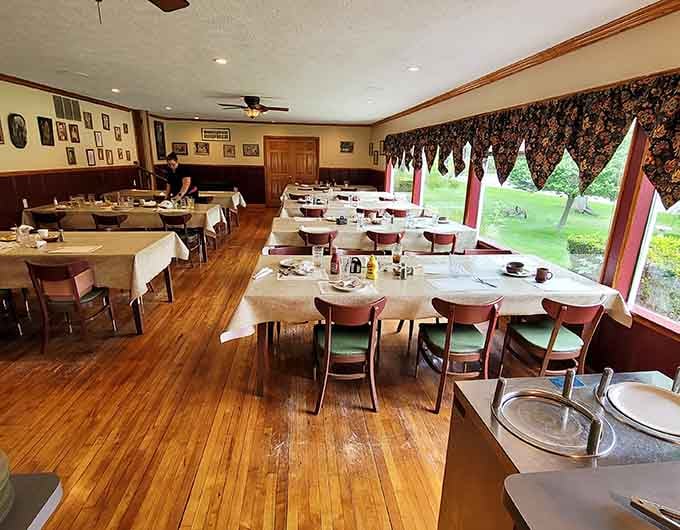 White tablecloths and windows overlooking green lawns create the kind of dining room where time slows down in the best way.