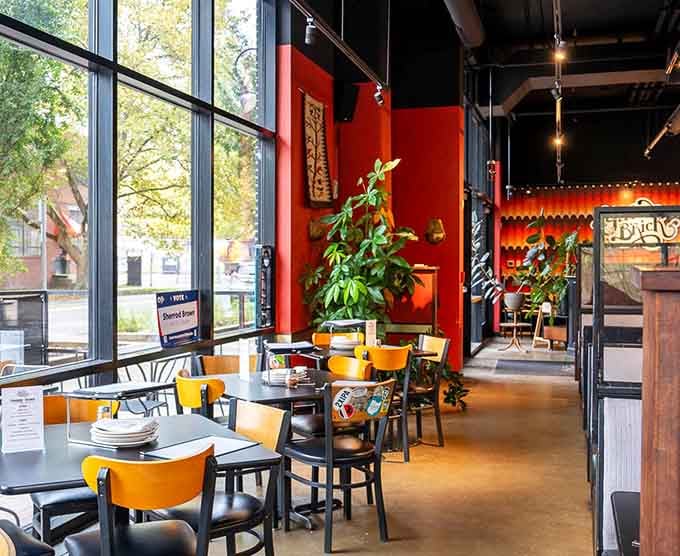 Bright yellow chairs and red walls create an energy that makes every meal feel like a celebration.