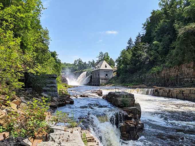 Water crashes over ancient rock formations while that historic building stands witness to nature's endless power show.