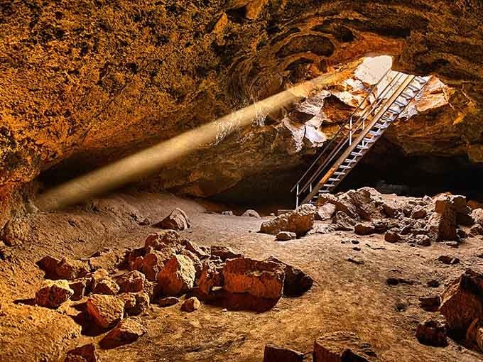 That ladder leads down into adventure, with golden light painting the volcanic walls in warm amber tones.