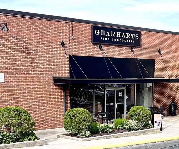 Clean brick lines and elegant black awnings signal serious chocolate business happening behind those glass doors.