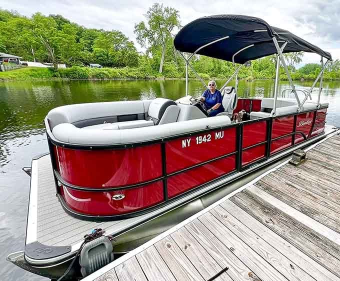 That cherry-red pontoon boat looks ready to cruise the waterways in absolute comfort and style.