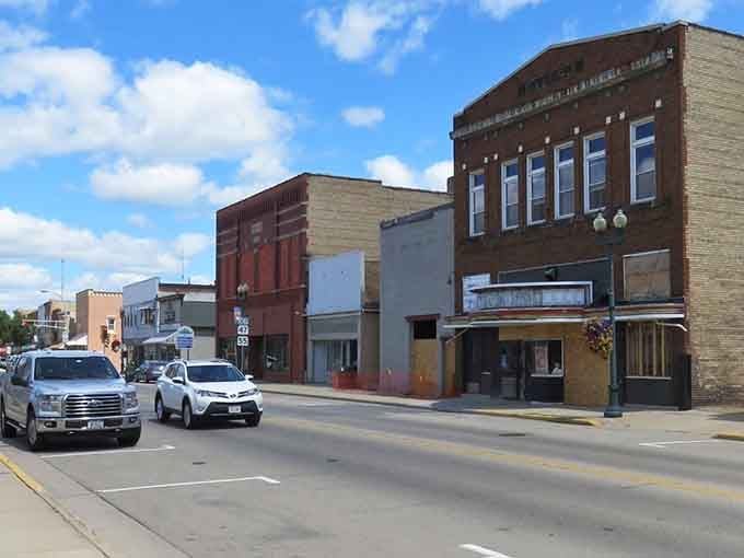 Historic buildings stand shoulder to shoulder along this wide street, their varied facades telling stories of different eras and dreams.