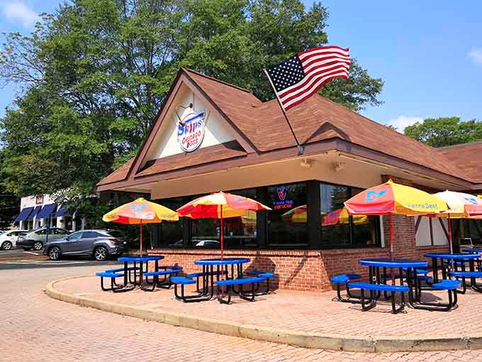 The American flag waves proudly above this hot dog haven, where outdoor seating meets serious Chicago dog craftsmanship.
