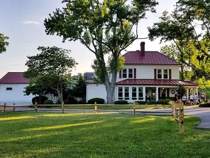 Golden hour hits this white farmhouse like a Norman Rockwell painting come to life.