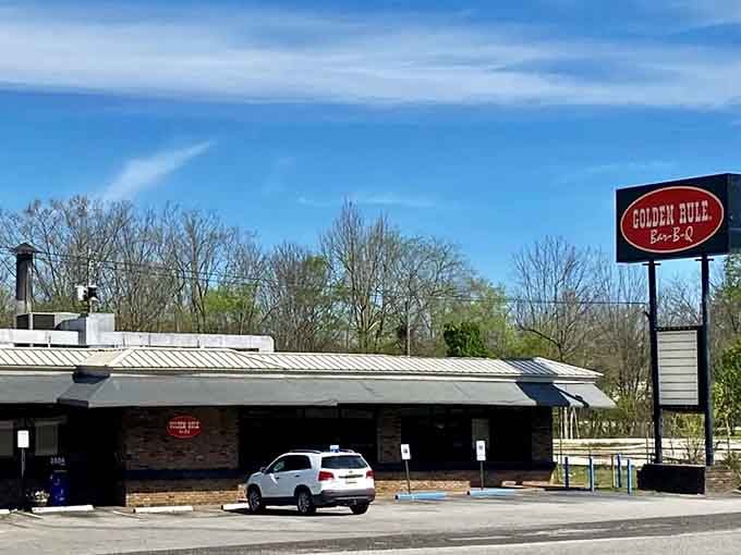 That roadside sign stands tall like a delicious lighthouse, promising smoky salvation to every passing traveler with taste buds.