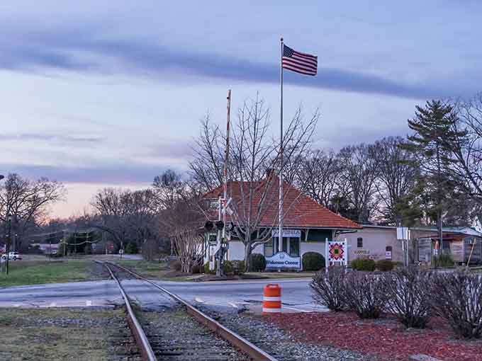 Dawn breaks over this charming depot, where the American flag waves above tracks that once carried countless dreams.