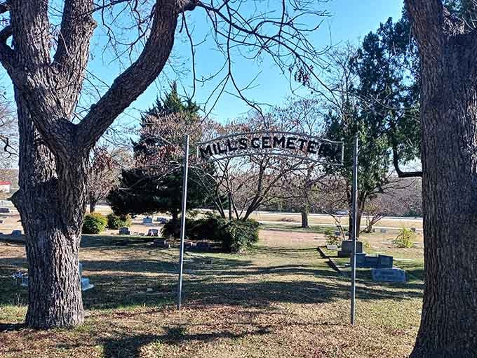 That "Mills Cemetery" archway welcomes visitors to a quiet pocket of history tucked between the gnarled embrace of old trees.