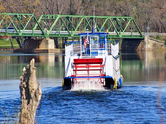 Watch that paddle wheel kick up white foam as this beauty glides past the historic green bridge like a postcard.