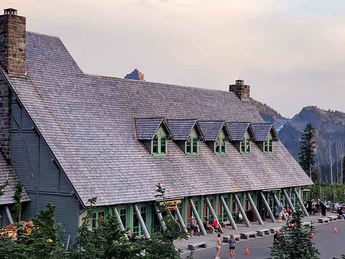 Sunset paints this historic lodge in soft pastels while Mount Rainier looms majestically&mdash;nature's own postcard moment captured perfectly.