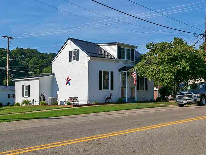 A white house with a patriotic star stands proudly on the corner, embodying small-town America at its most genuine and welcoming.