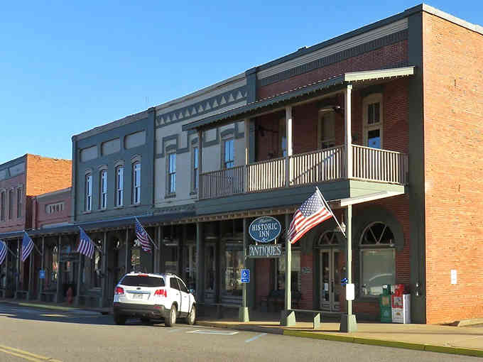 Second-story balconies overlook streets where neighbors still wave and nobody's checking their phones constantly.