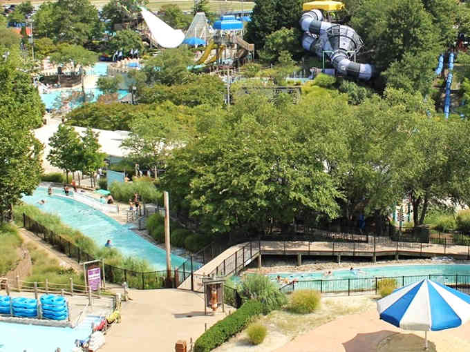 Mature trees shade the pathways while slides tower overhead, blending nature with thrilling water adventures perfectly.