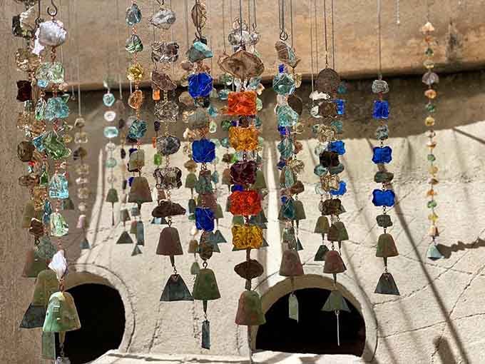 These handcrafted wind chimes catch the light like jewels, each one singing its own unique desert song.