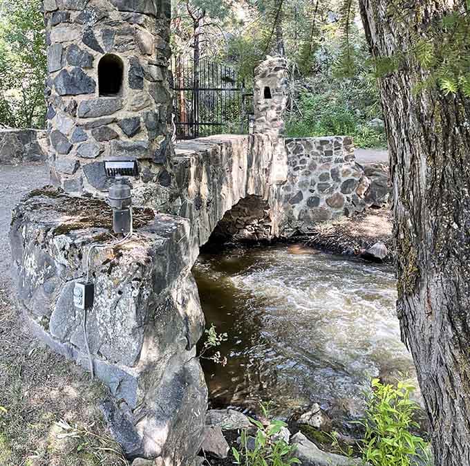 Bear Creek flows beneath ancient-looking stonework, proving that Colorado does medieval European architecture better than you'd ever expect.