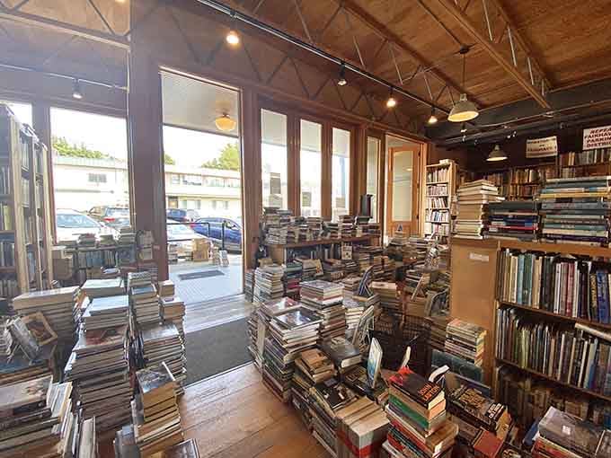 Books stacked like Jenga towers, daring you to pull one out without toppling your entire afternoon plans.