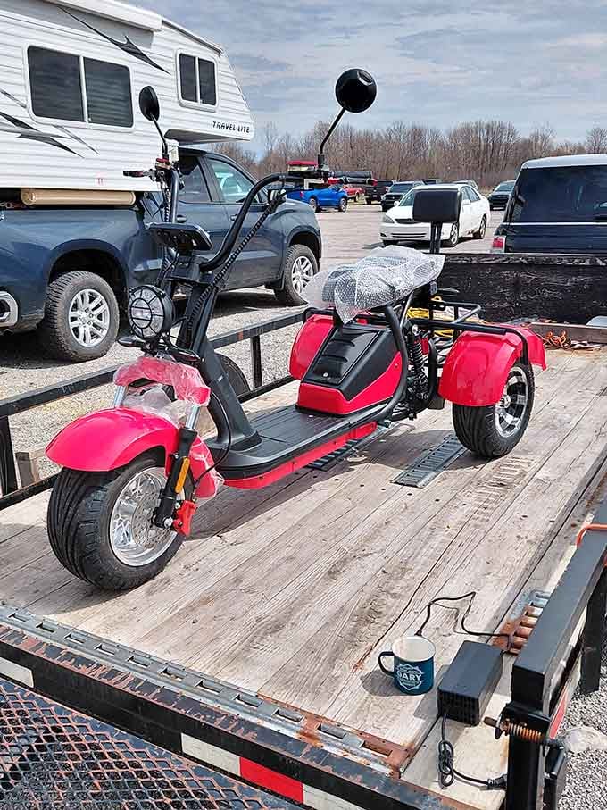 Nothing says "I need this" quite like a bright red electric scooter parked on a flatbed trailer.