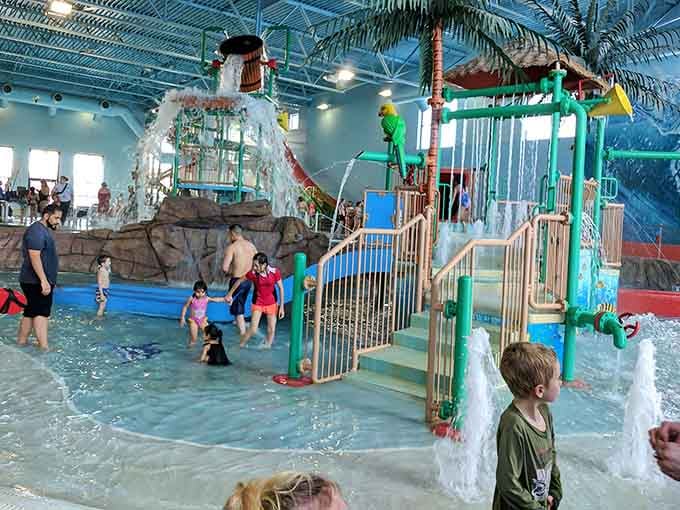 Kids navigate the colorful play structure like tiny explorers discovering their own personal water kingdom under palm trees.