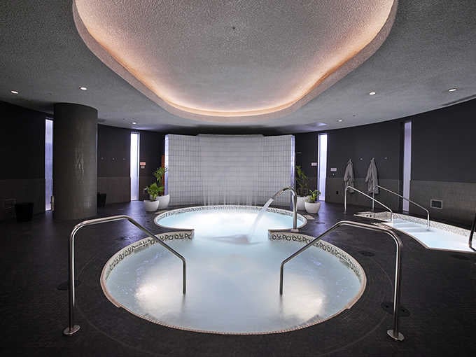 Modern design meets ancient relaxation in these illuminated pools where stress simply evaporates into thin air.