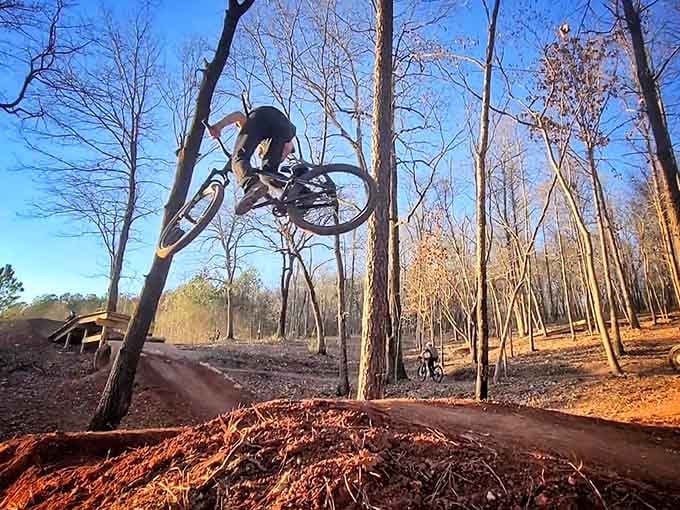 Catching serious air against blue sky, this rider demonstrates why downhill biking beats sitting in traffic any day.
