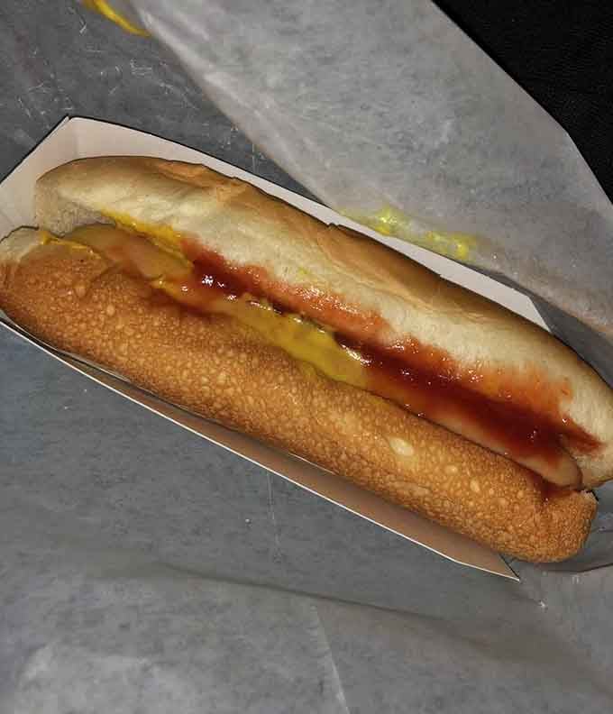 A perfectly grilled hot dog with mustard and chili, proving simplicity beats complexity every single time.
