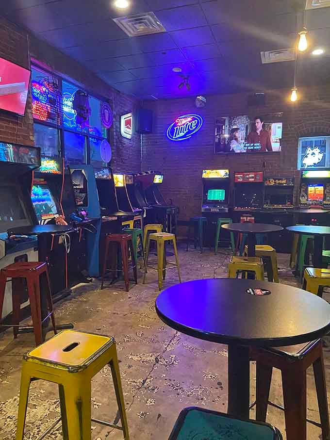 Purple lighting bathes the space in arcade ambiance while Miller Lite glows approvingly from the brick wall.