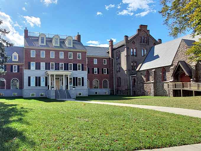 Colonial brick and stone buildings cluster together like old friends sharing centuries of stories on this green lawn.