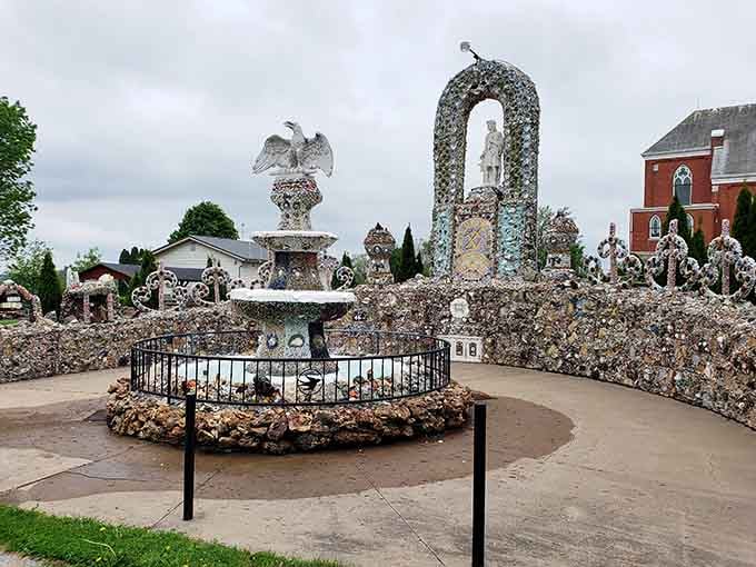 Thousands of stones, shells, and glass pieces create a shimmering wonderland of patriotic and religious devotion.